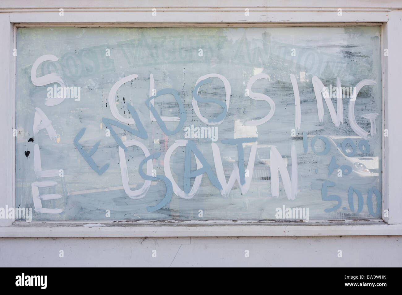 A closing down sale window is written on smeared whitewashed glass on a ...