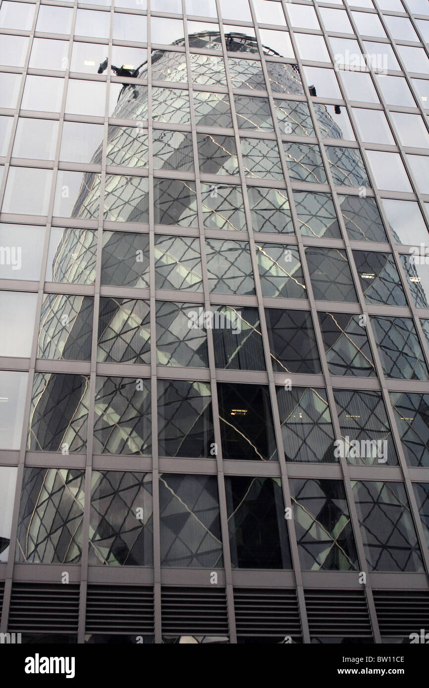 A reflection of the Gherkin building, seen in the glass facade of ...