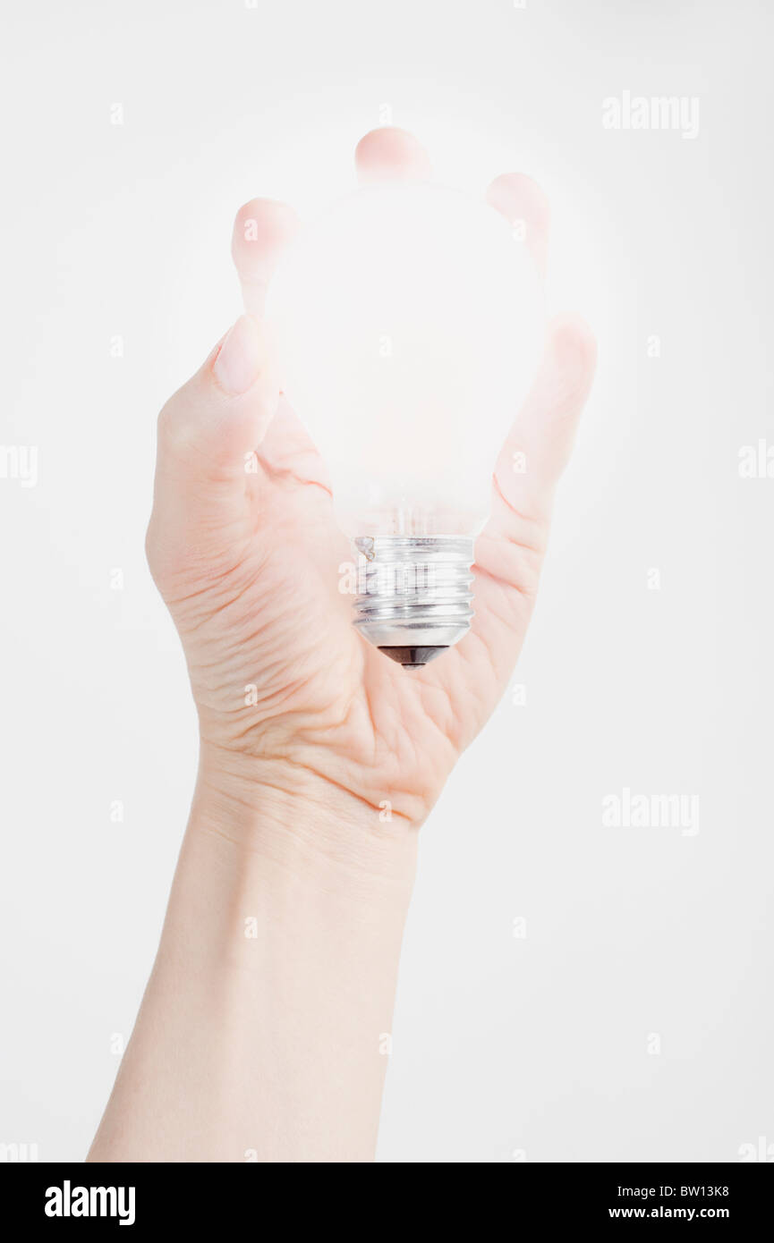 Hand holding a glowing light bulb Stock Photo - Alamy
