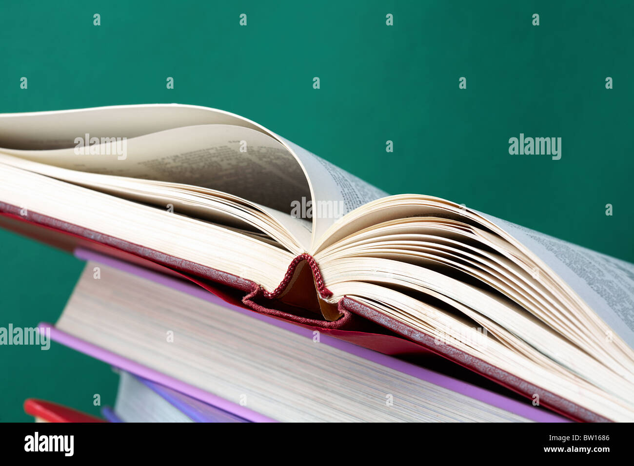 Colorful stack of textbooks with open book on its top Stock Photo - Alamy