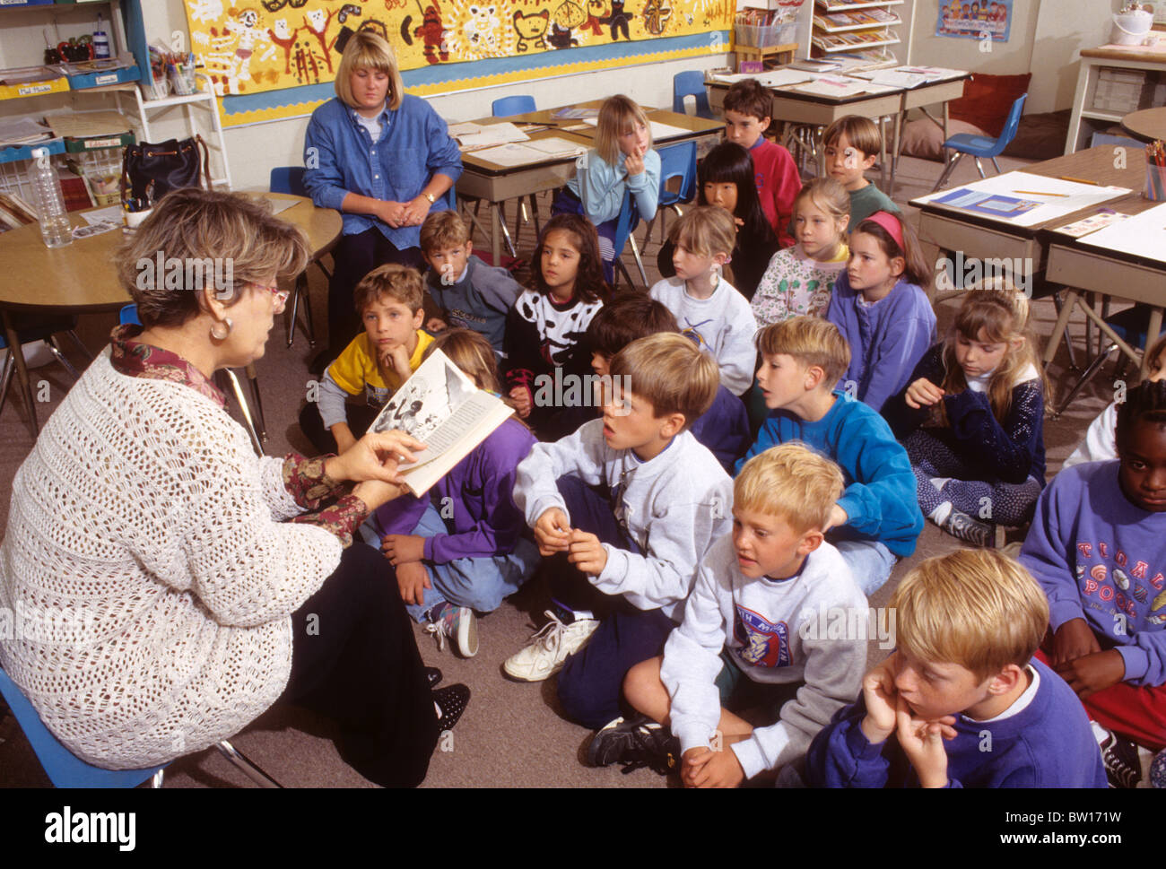 teacher read class story book listen group aide student pupil boy girl ...