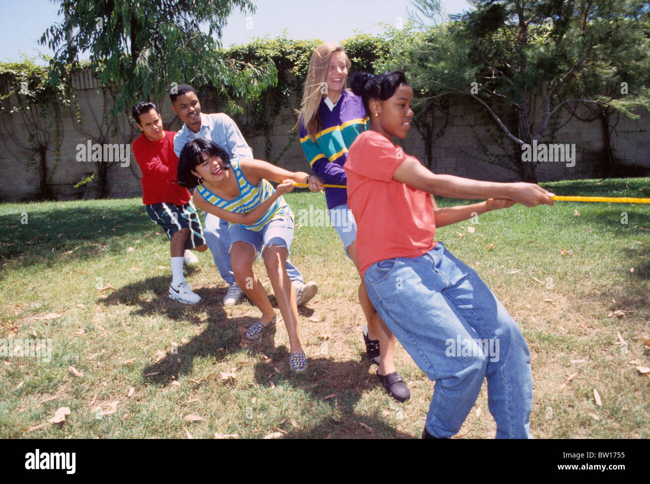 mixed race group teen male boy female girl tug-o-war tug of war game ...