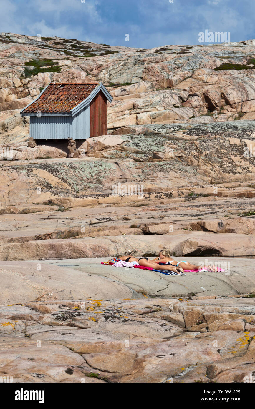 Two girls sunbathing on the rocks Stock Photo - Alamy