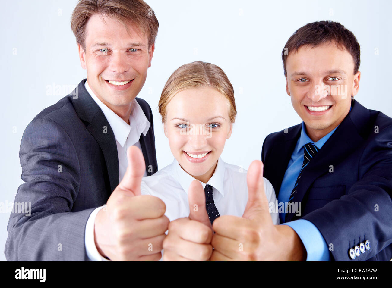 Image of happy business people showing thumbs up and smiling Stock ...