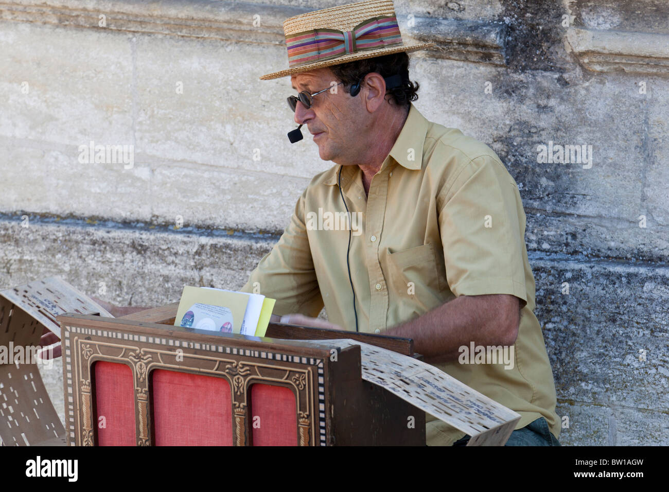 A street musician plays a Limonaire Fournier folded paper organ in ...
