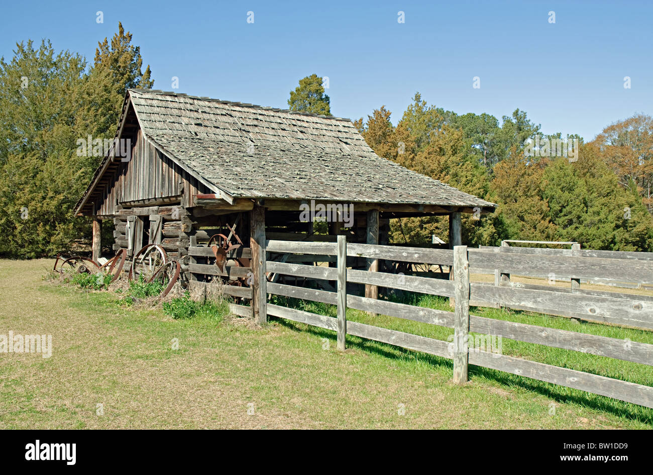 An old wooden log barn with a wooden fence on a farm in the rural ...