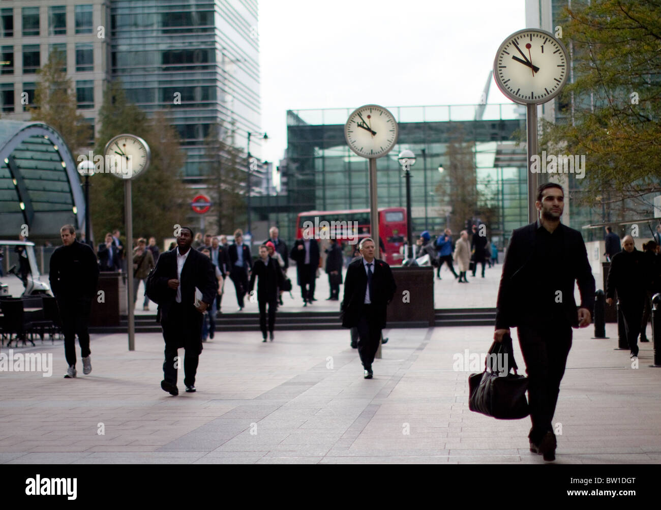 Clocks outside Canary Wharf station, London UK with city workers , Six ...
