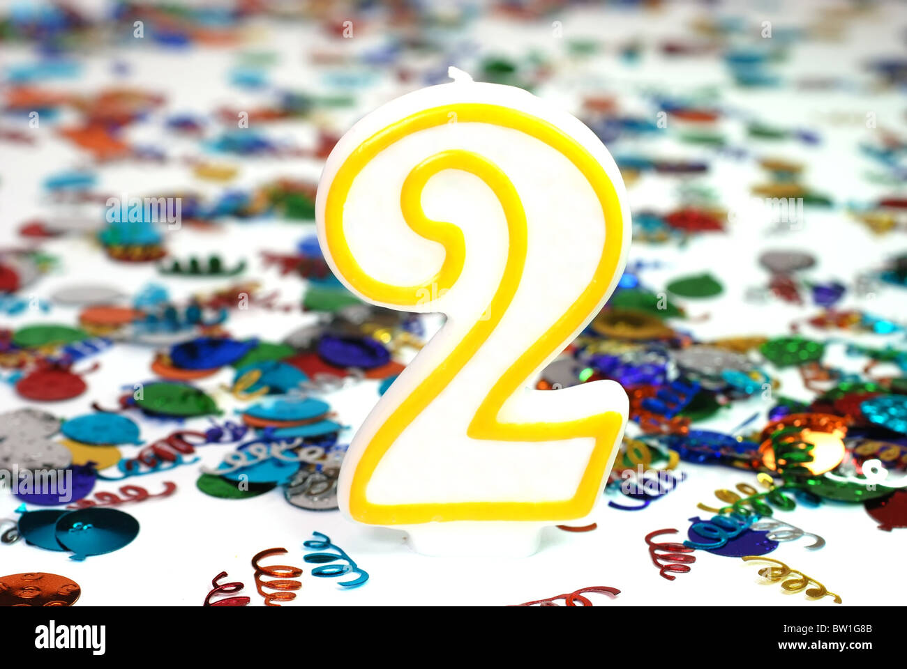 Number 2 celebration candle with confetti Stock Photo - Alamy
