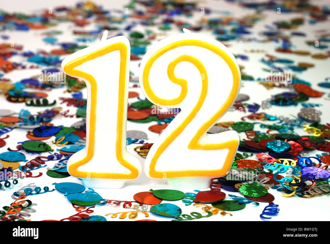 Number 12 celebration candle with confetti Stock Photo - Alamy