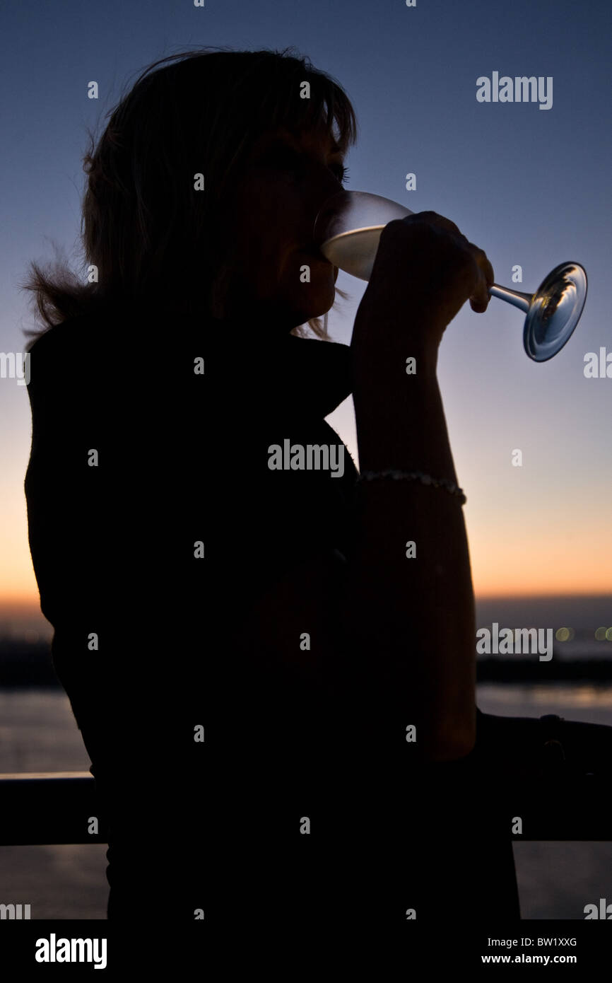 woman drinking champagne silhouetted dusk sky Stock Photo - Alamy