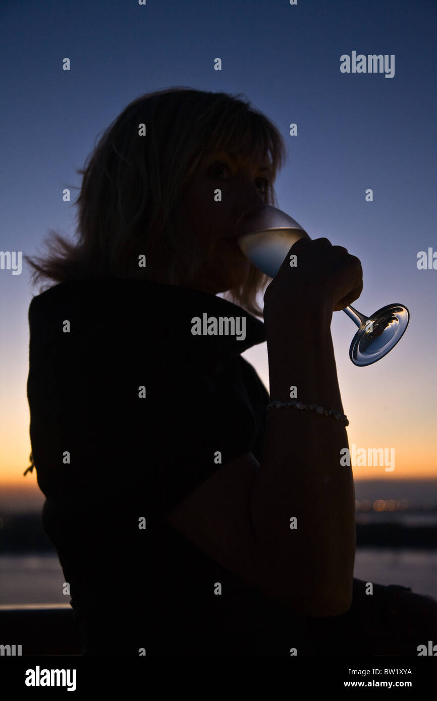 woman drinking champagne silhouetted dusk sky Stock Photo - Alamy