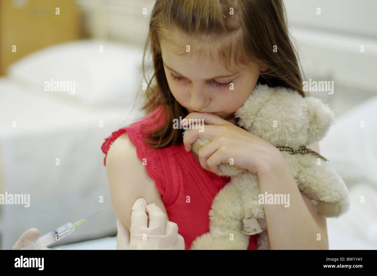 A child in a hospital ward receiving an injection from a nurse Stock ...