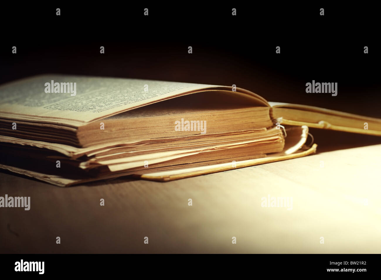 Old damaged book on the table on a dark background Stock Photo - Alamy