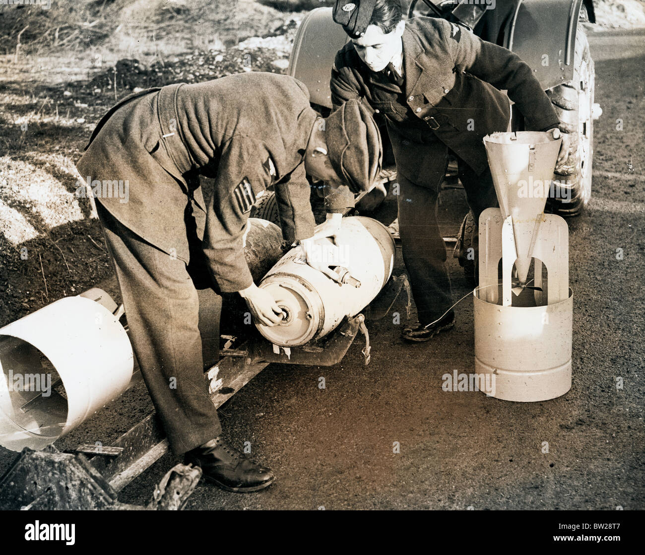 Technicians fitting fuses to 500lb bomb for fitting in rack of bomber ...
