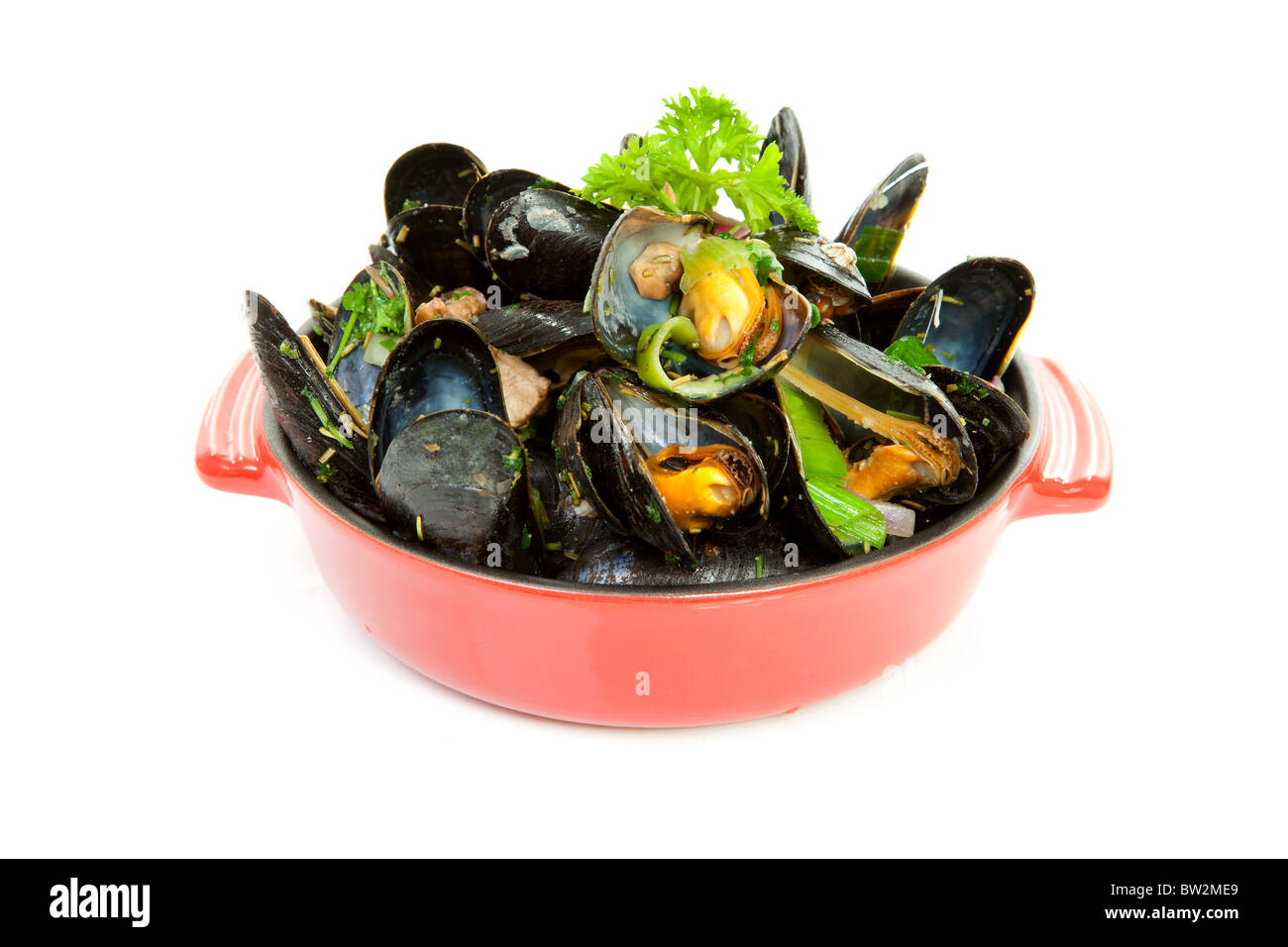 cooked mussels in red casserole over white background Stock Photo - Alamy