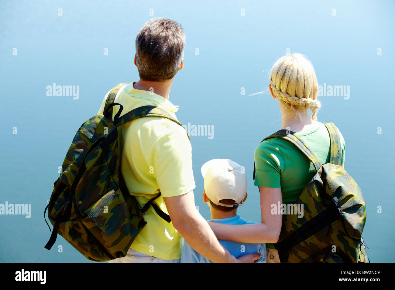 Back view of happy family on blue background Stock Photo - Alamy