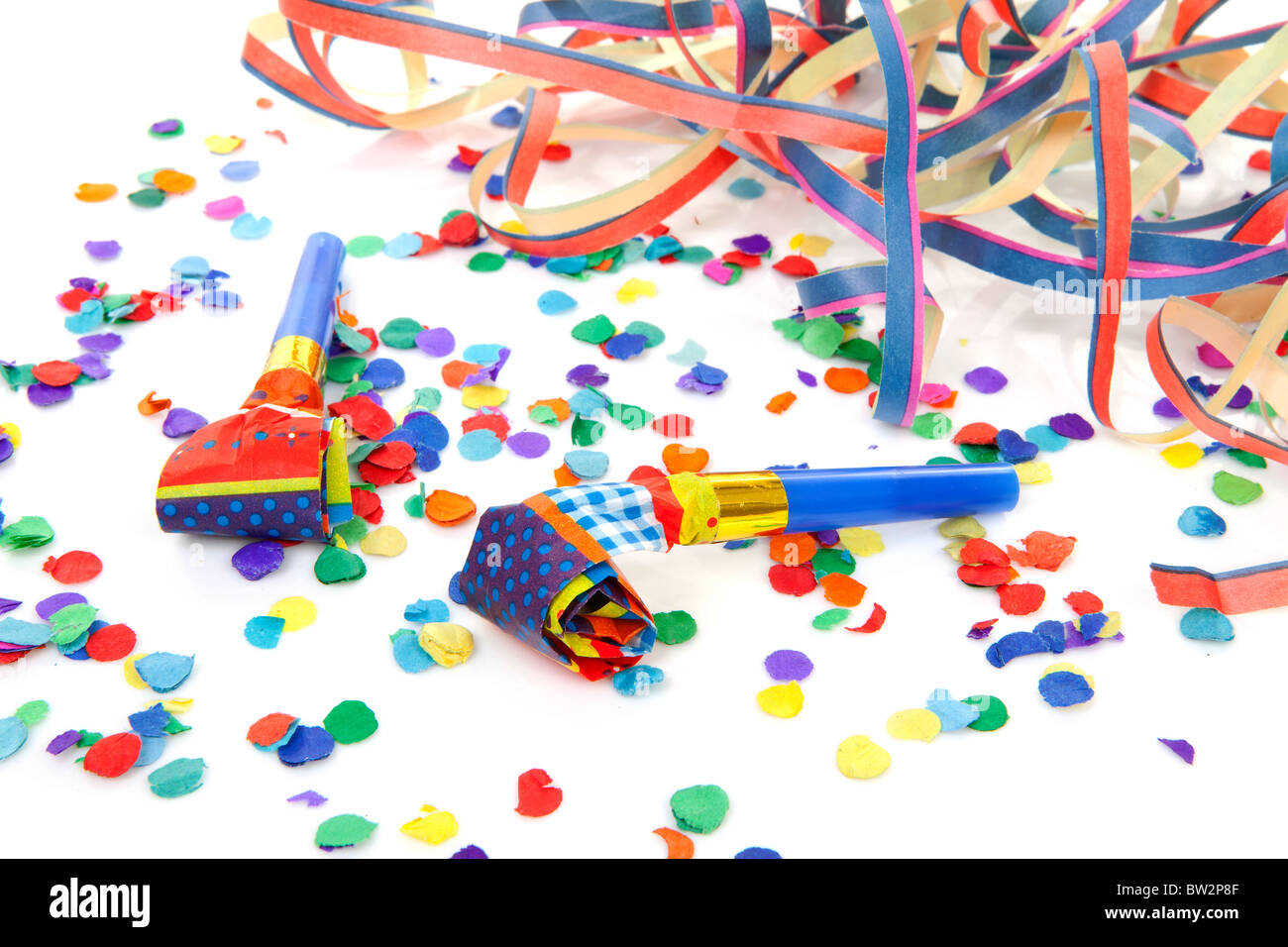 colorful party attributes with streamers, confetti and horns over white ...