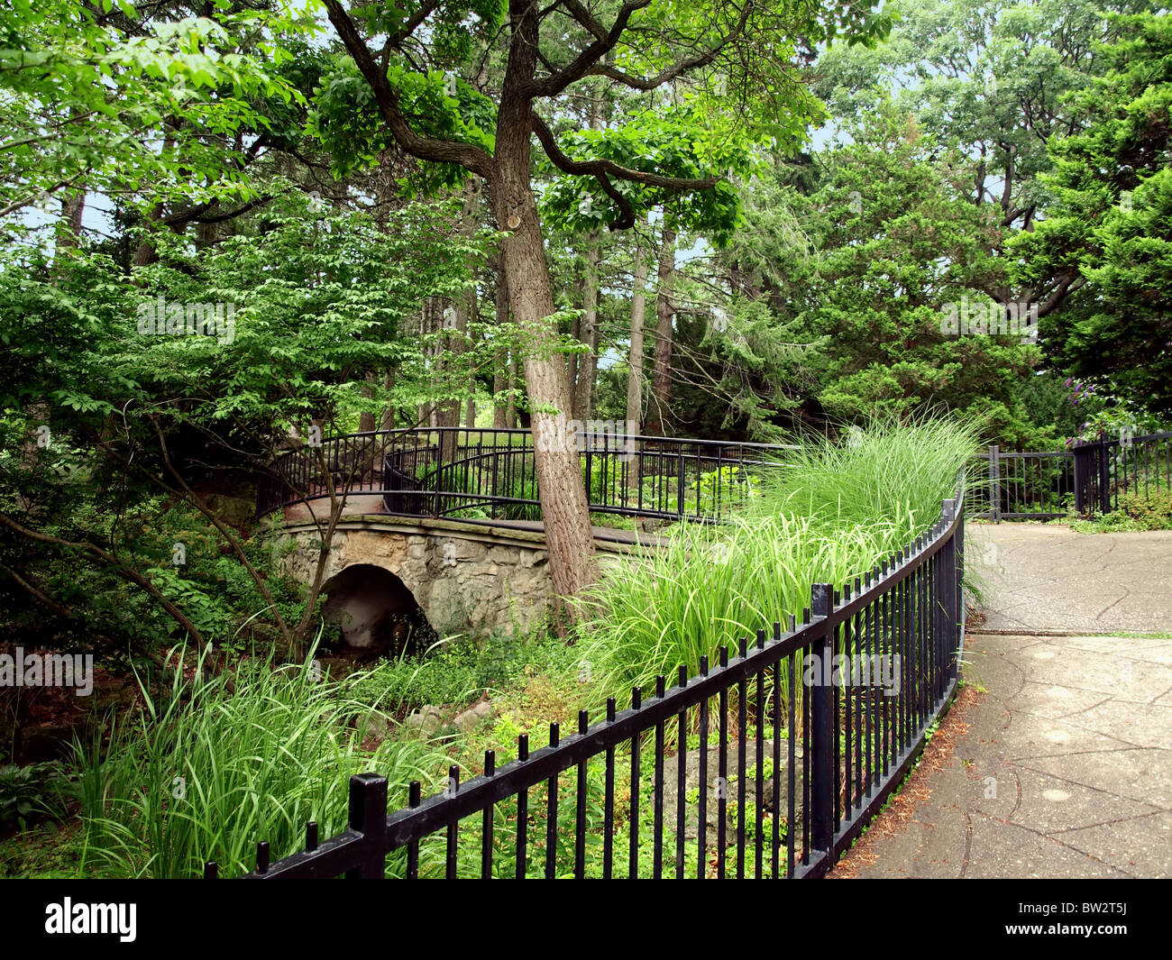 Pathway and romantic bridge in the park Stock Photo - Alamy