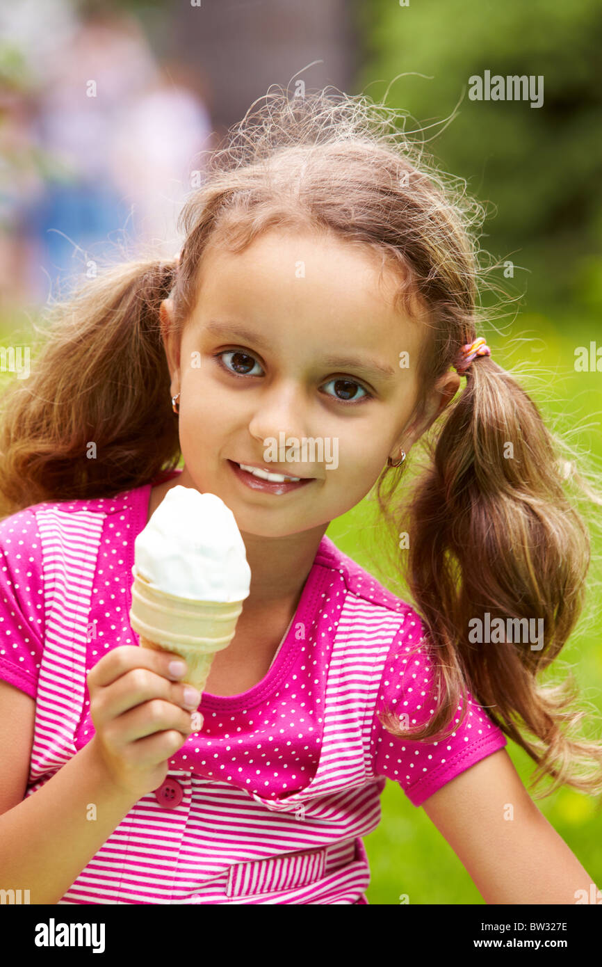 Portrait of pretty girl eating ice-cream outside Stock Photo - Alamy