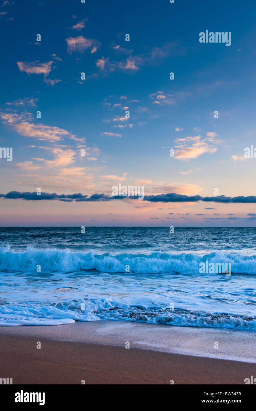 Ocean surf under pink sunset clouds Stock Photo - Alamy