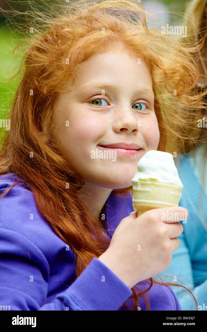 Portrait of pretty girl eating ice-cream outside Stock Photo - Alamy
