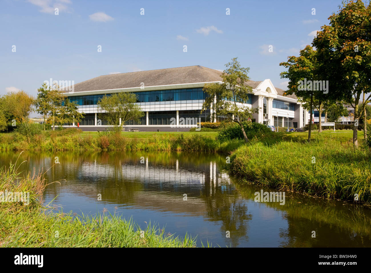 Modern office building beside lake Stock Photo - Alamy