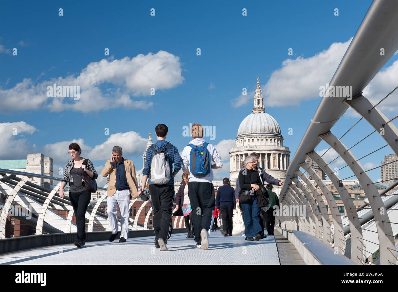 Group of people walking over the Millenium Bridge London Stock Photo ...