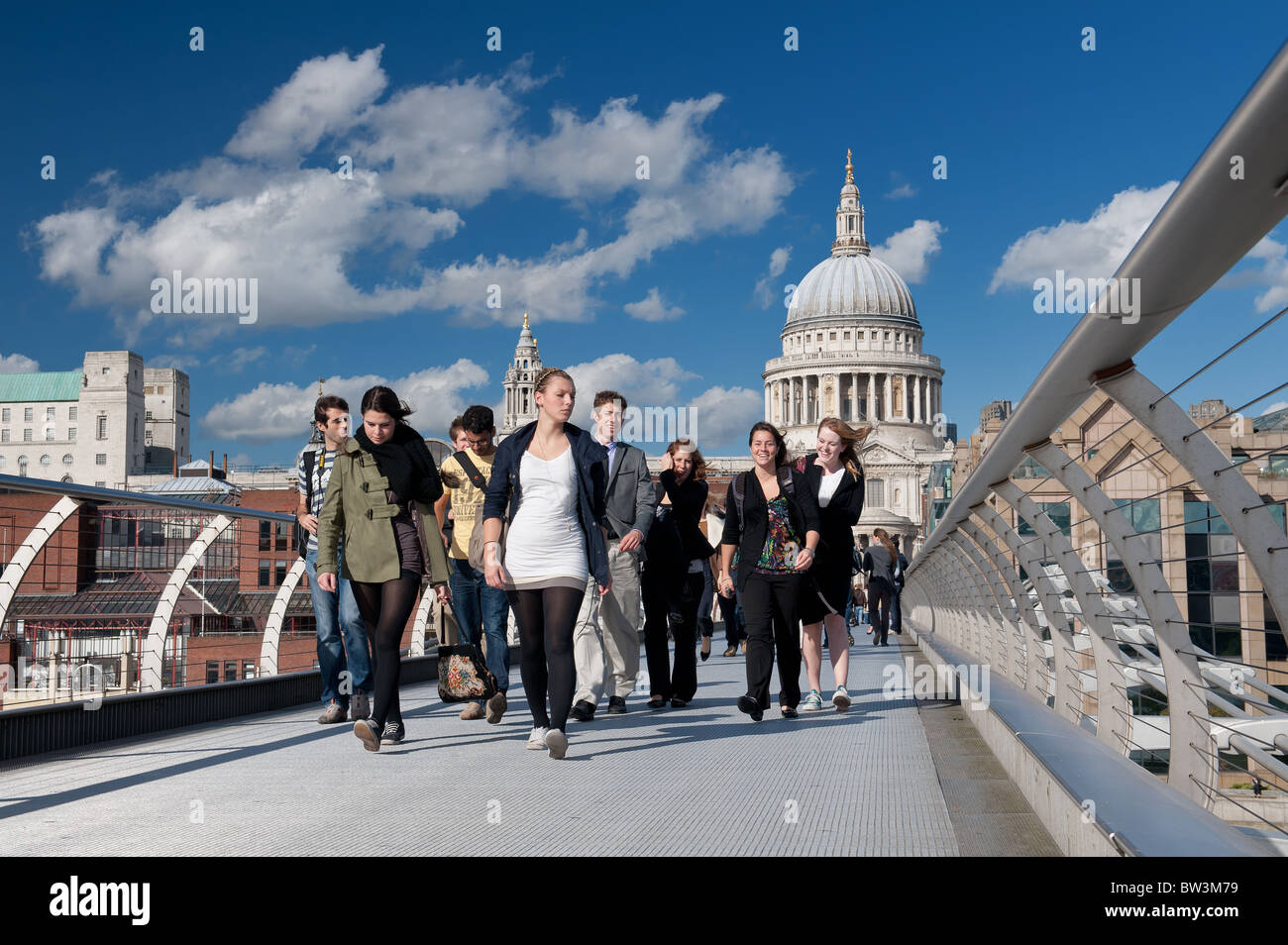 Group of people walking over the Millenium Bridge London Stock Photo ...