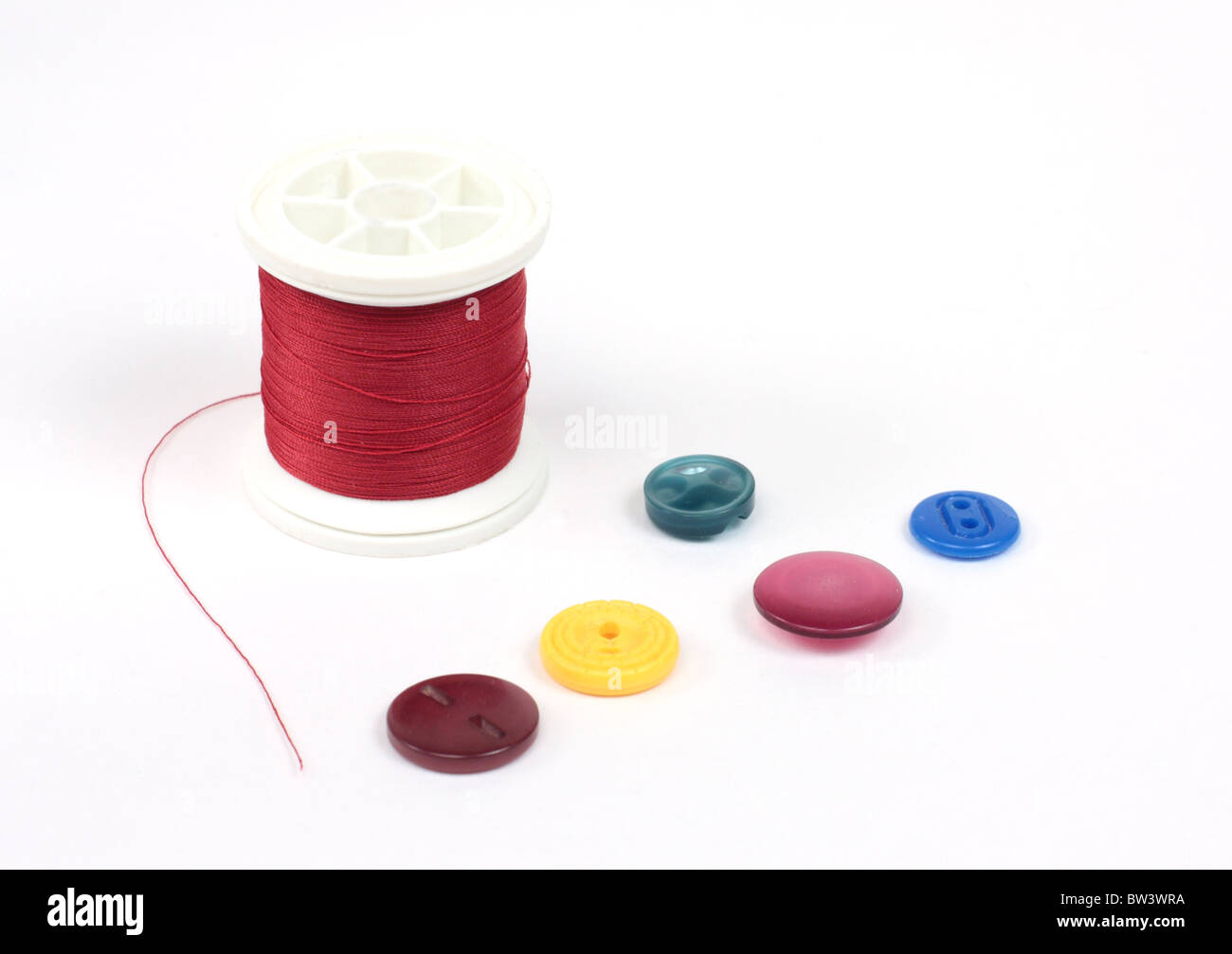 bright red thread and scattered colored buttons Stock Photo - Alamy