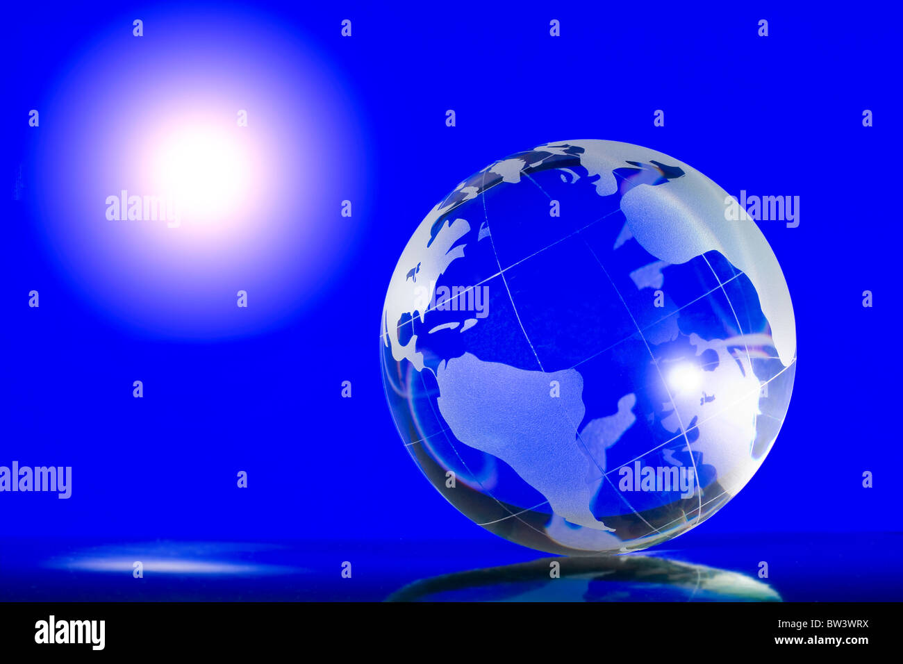 Glass globe with bright highlights on a blue background Stock Photo - Alamy