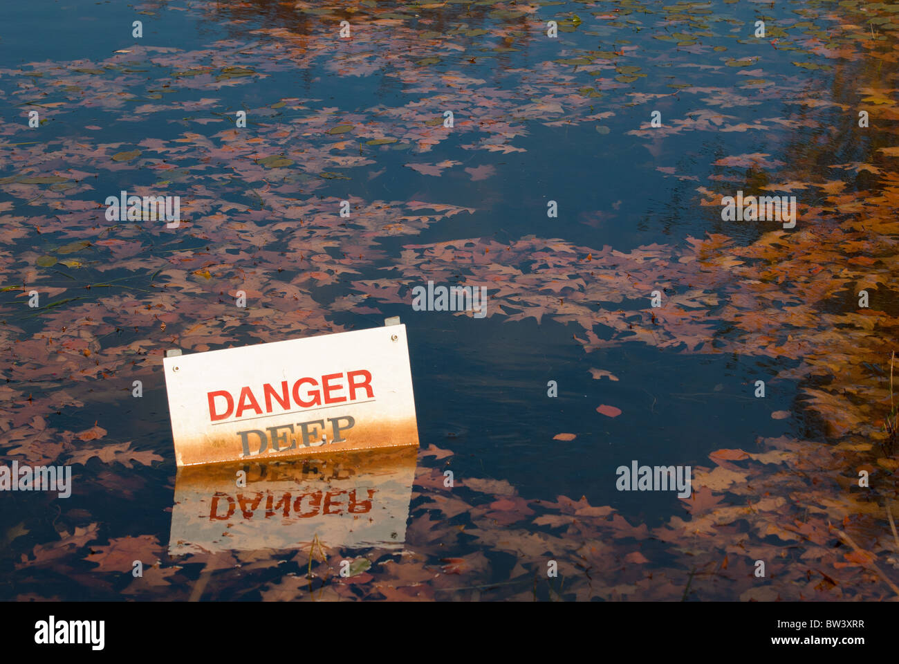 deep water warning sign in pond where water level is obscuring the ...