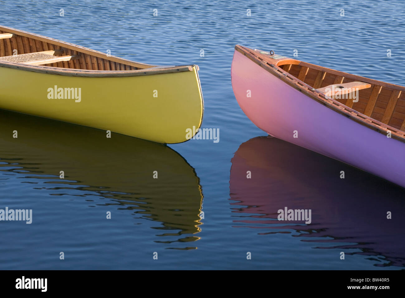 Pink and yellow canoes floating in lake, Algonquin Park, Ontario ...