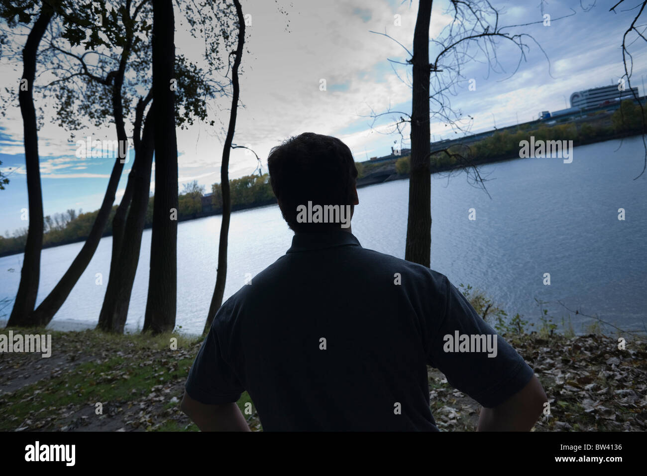 Young man in front of a river Stock Photo - Alamy
