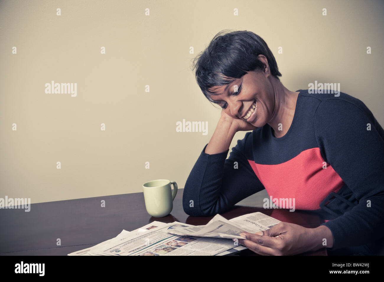 Black woman, age 44, reading a newspaper Stock Photo - Alamy