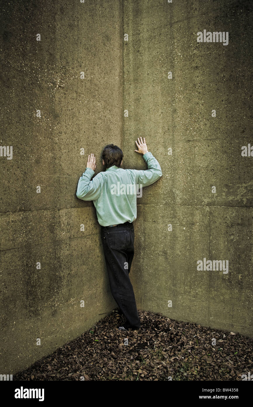 Man standing at the corner of two concrete walls Stock Photo - Alamy