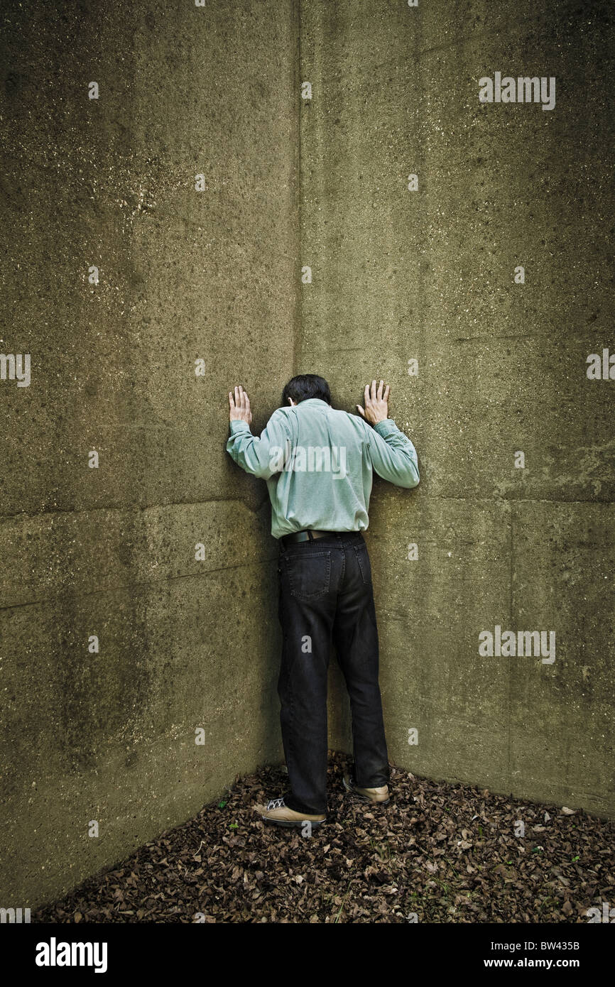 Man standing at the corner of two concrete walls Stock Photo - Alamy