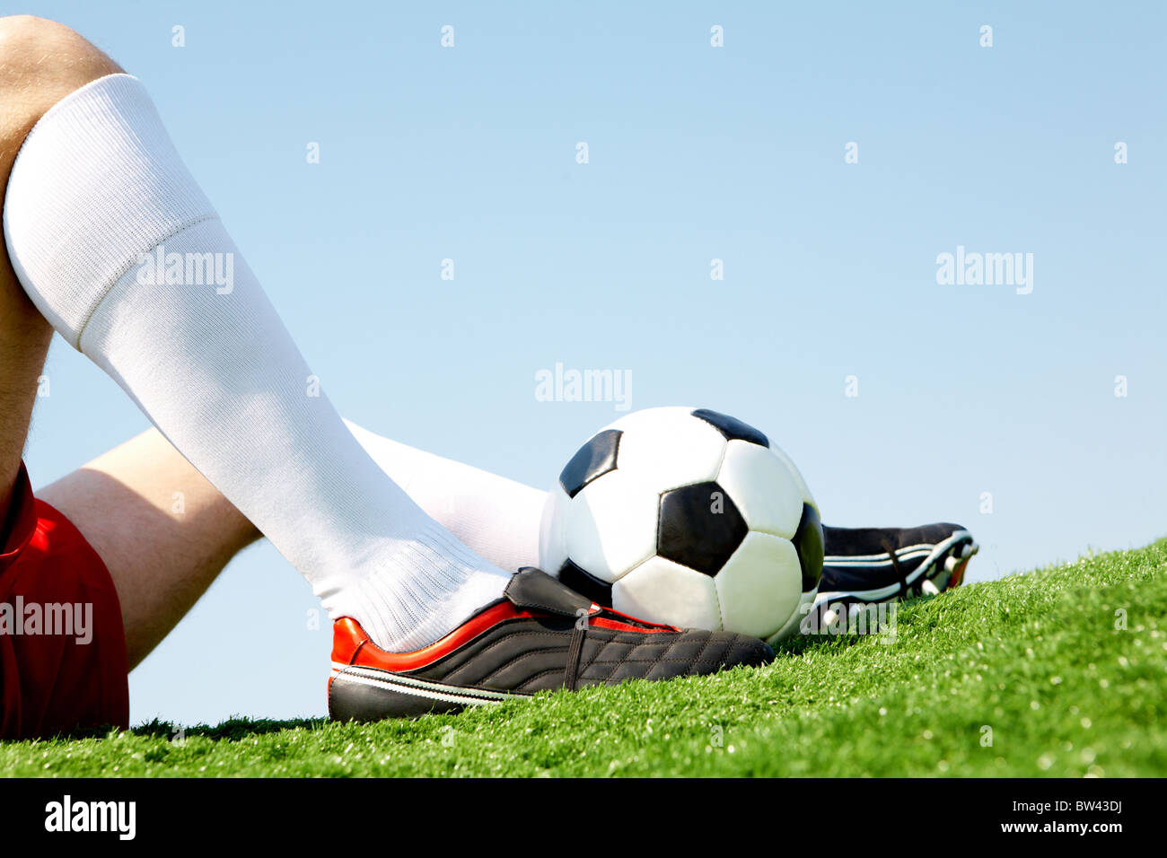 Horizontal image of seated player leg with soccer ball near by Stock ...