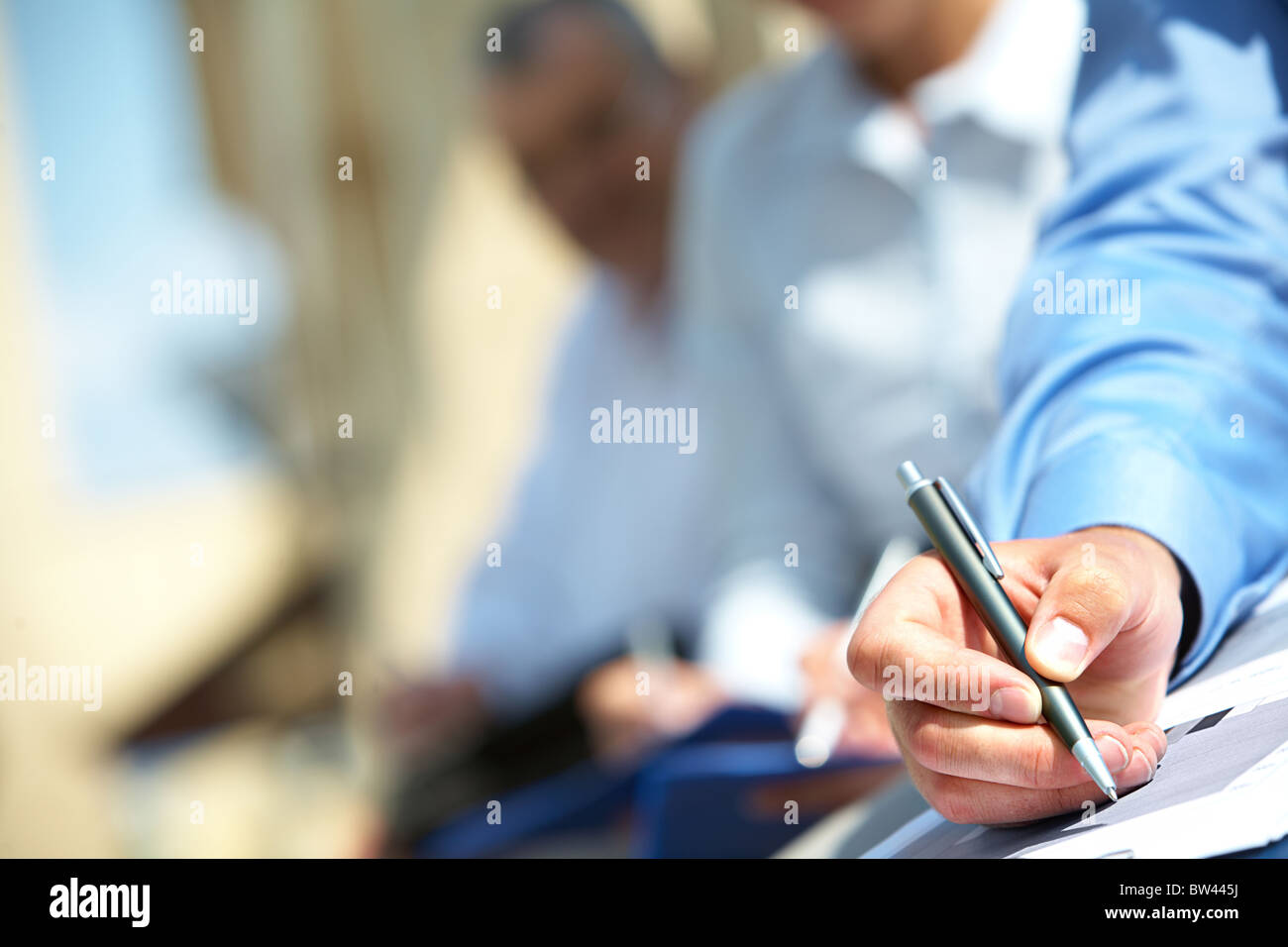 Male hand over paper making notes at seminar Stock Photo - Alamy
