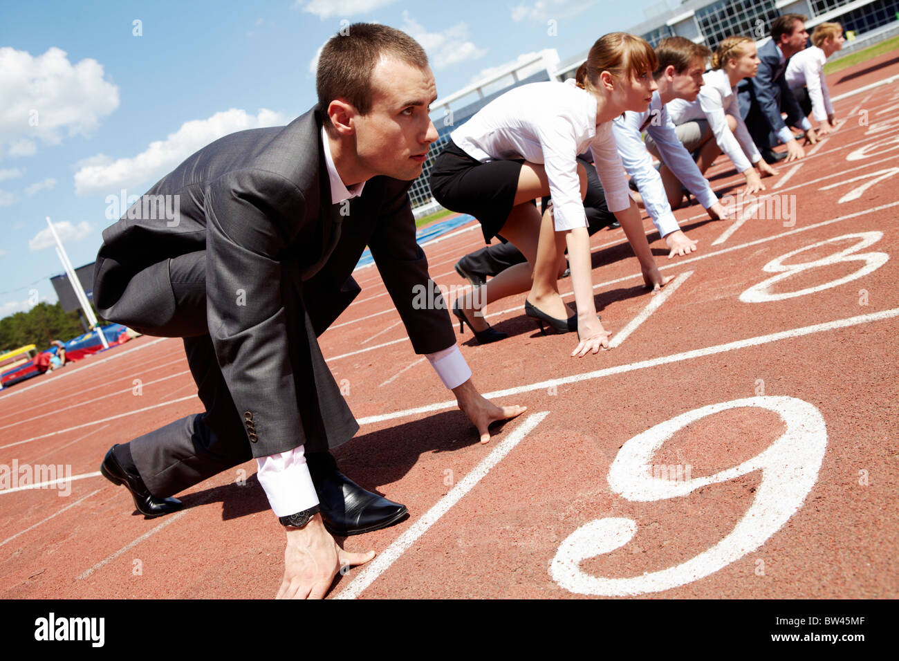 Row of business people getting ready for race Stock Photo - Alamy
