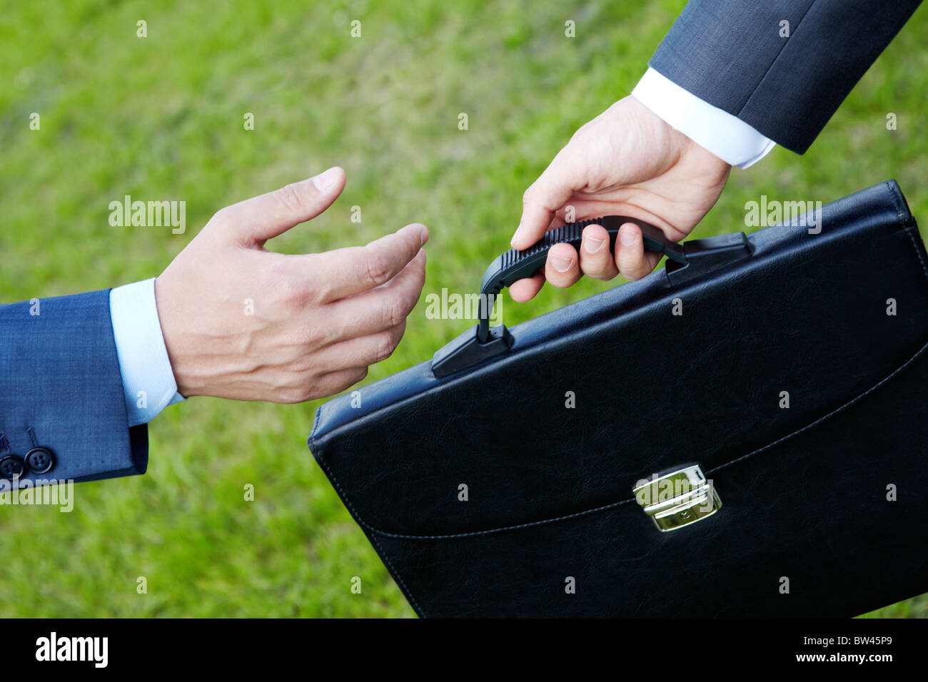 Photo of human hands giving and taking a black briefcase Stock Photo ...