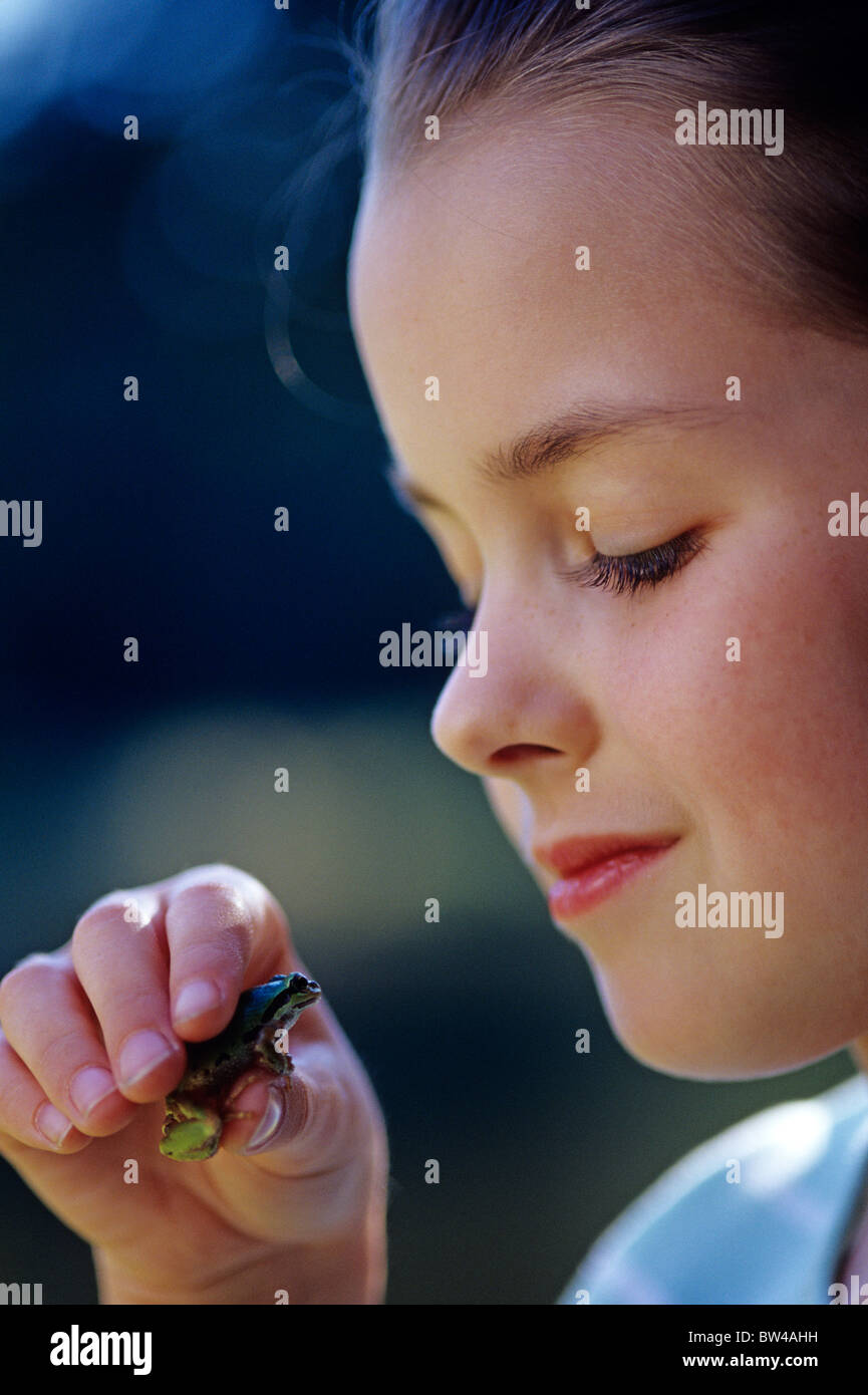 Green tree frog being held by young girl at park Stock Photo - Alamy