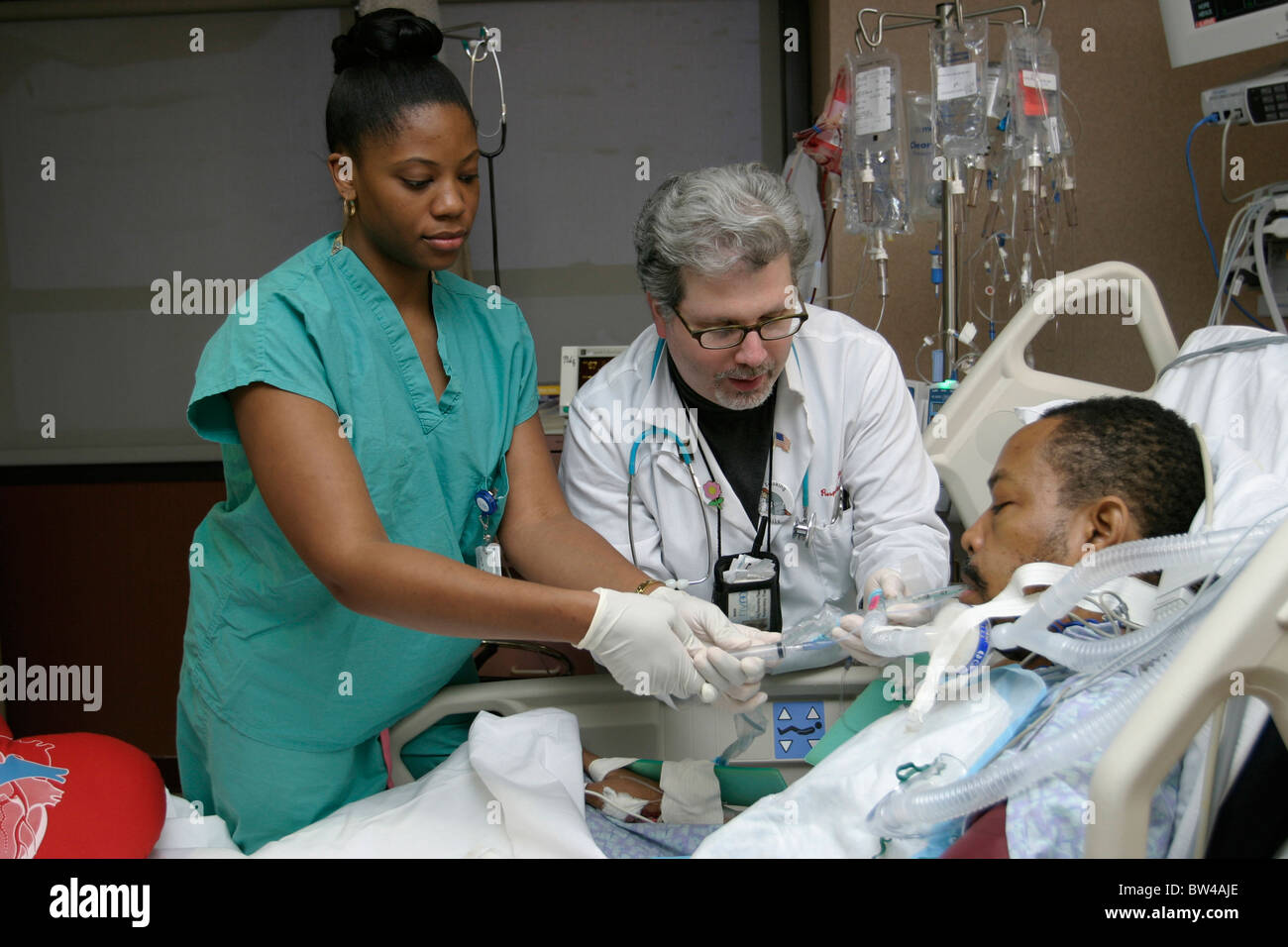 Nurse and pulmonary therapist with a patient in the cardiac intensive ...