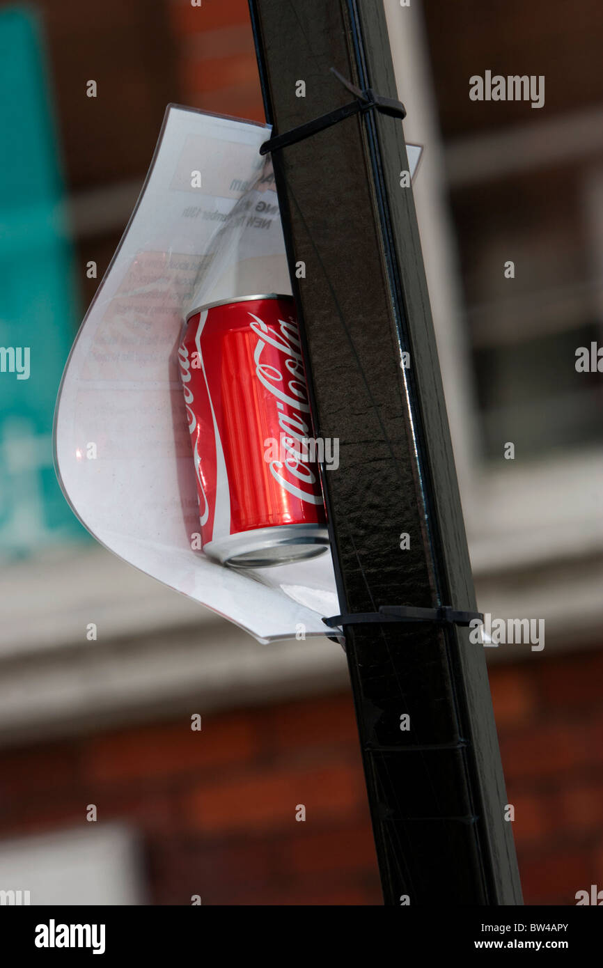 An empty can of pop discarded behind a poster in Brighton, East Sussex ...