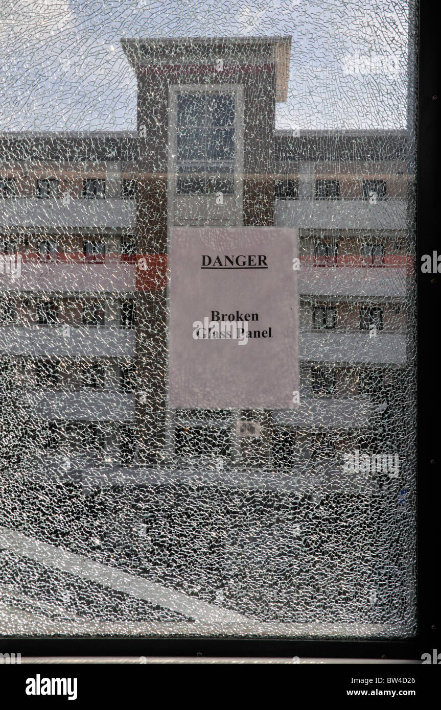 Danger notice on broken glass window panel on station platform with ...