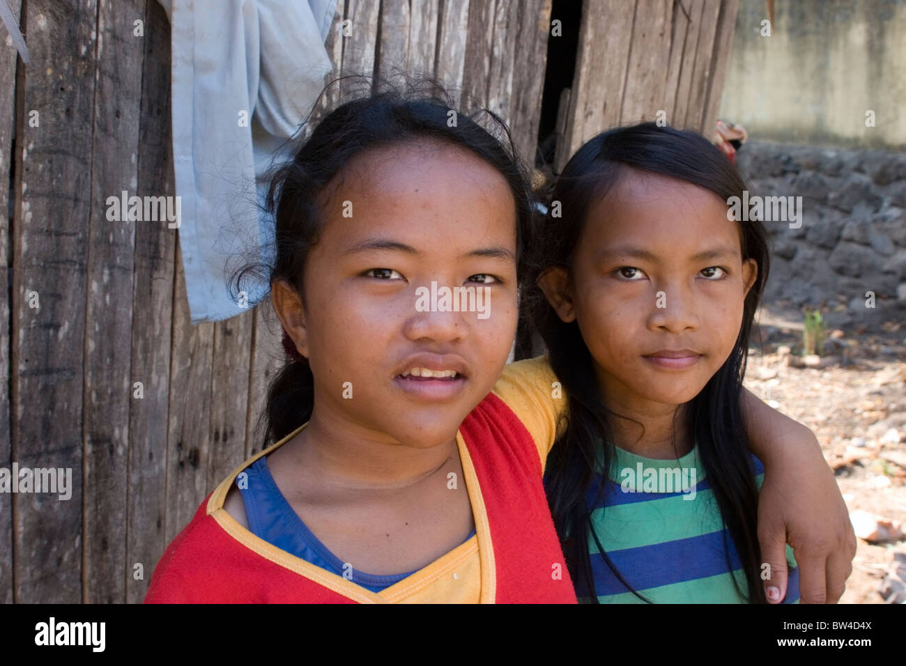Two young girls living in poverty pose for a portrait at their home in ...