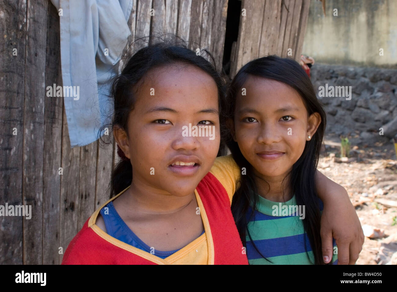 Two young girls living in poverty pose for a portrait at their home in ...