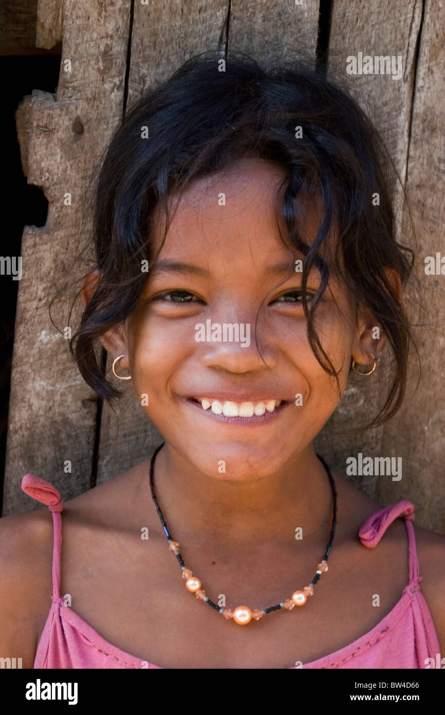 A young girl living in poverty poses for a portrait at her wood home in ...