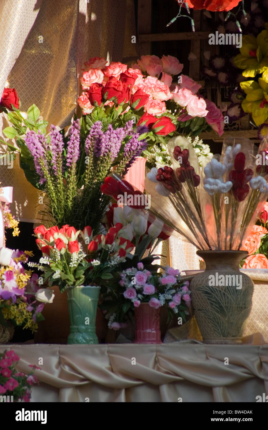 Colorful flowers, including red roses, are on display at a shop on ...