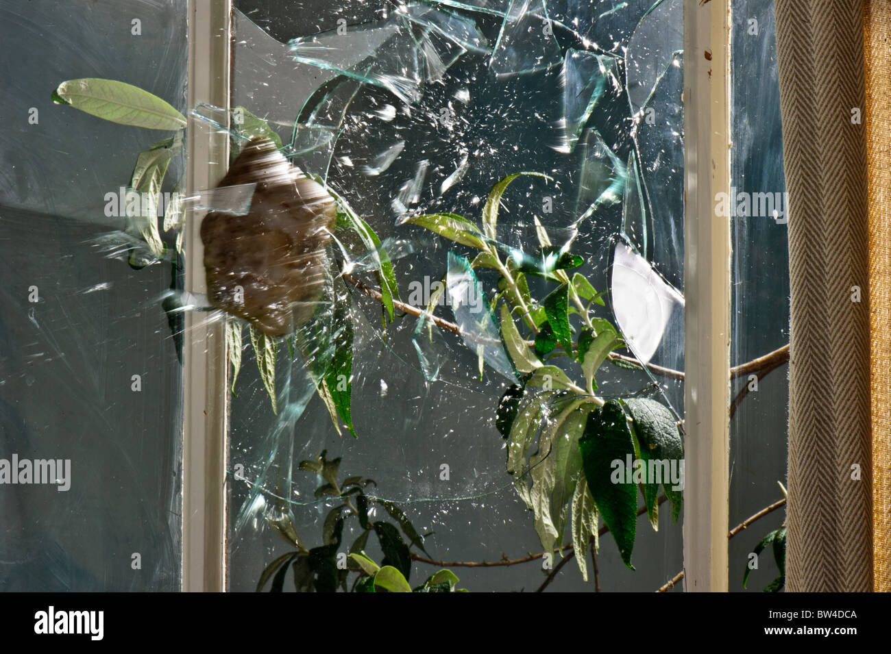 Stone smashes house window Stock Photo - Alamy