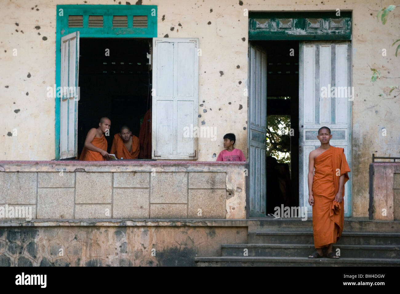 A Buddhist monk who lives at Wat Bangkok is standing on the front steps ...